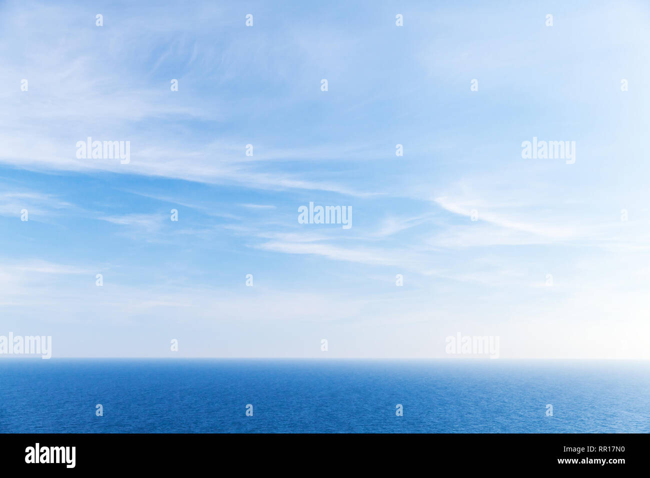 Blue sky background, white clouds over still ocean Stock Photo - Alamy