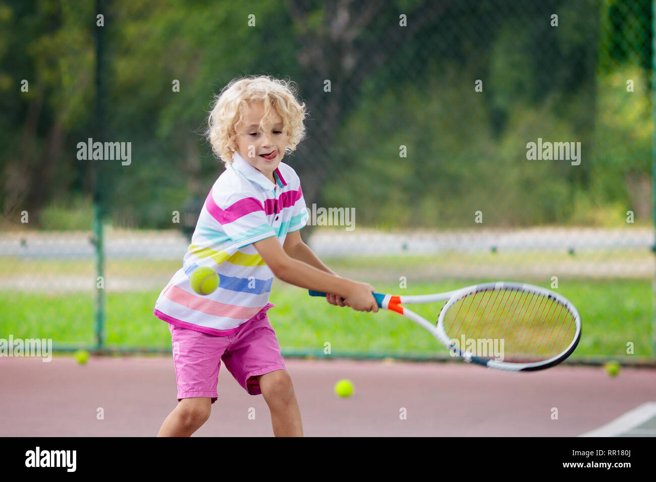 Child playing tennis on indoor court. Little boy with tennis racket and ...