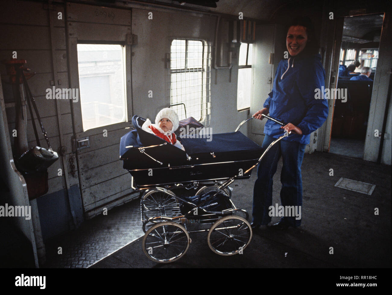 British Rail guard with mother and child in pram in train guards van on ...