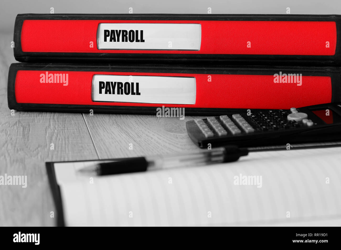 Red folders with payroll written on the label on a desk with selective ...