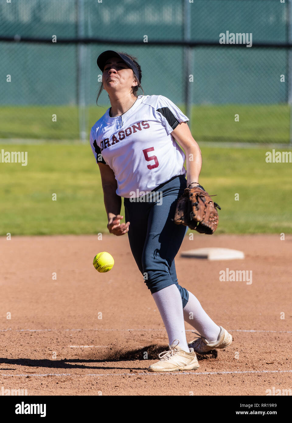 Softball player in white uniform releasing a pitch during right hand ...
