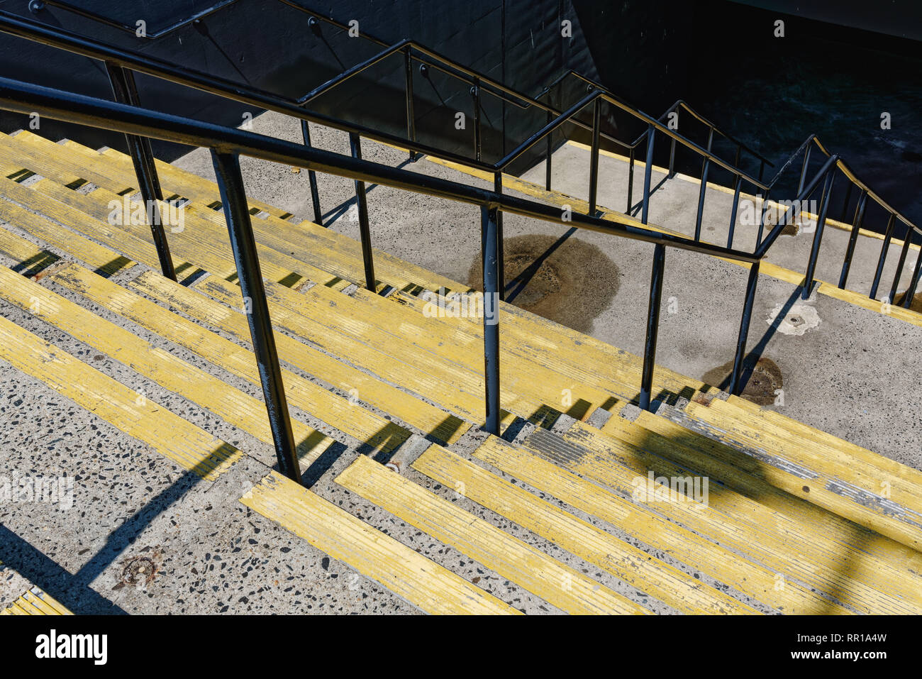 looking down the subway steps concrete stairway with safety yellow ...