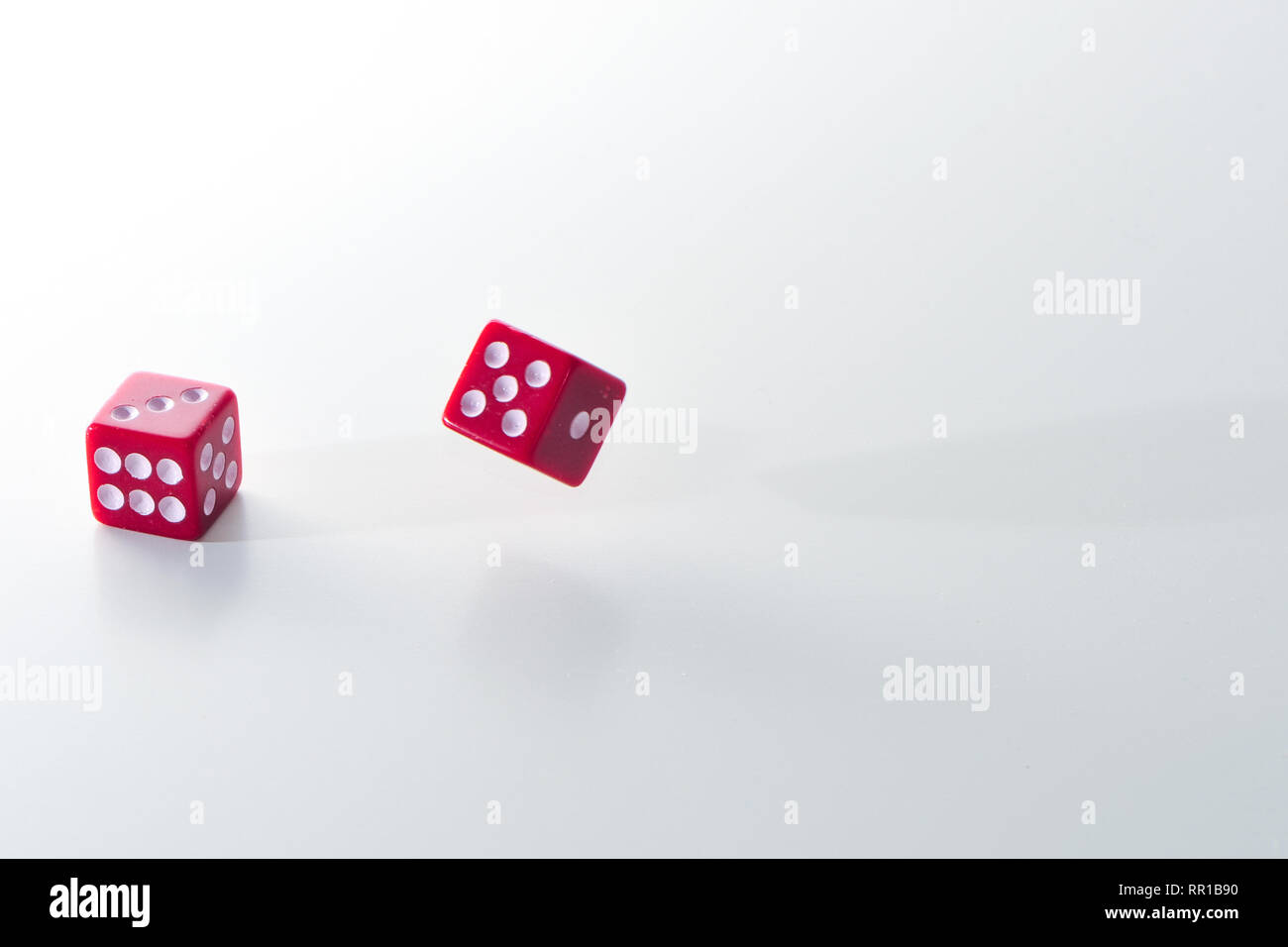 rolling red dice on white background Stock Photo - Alamy