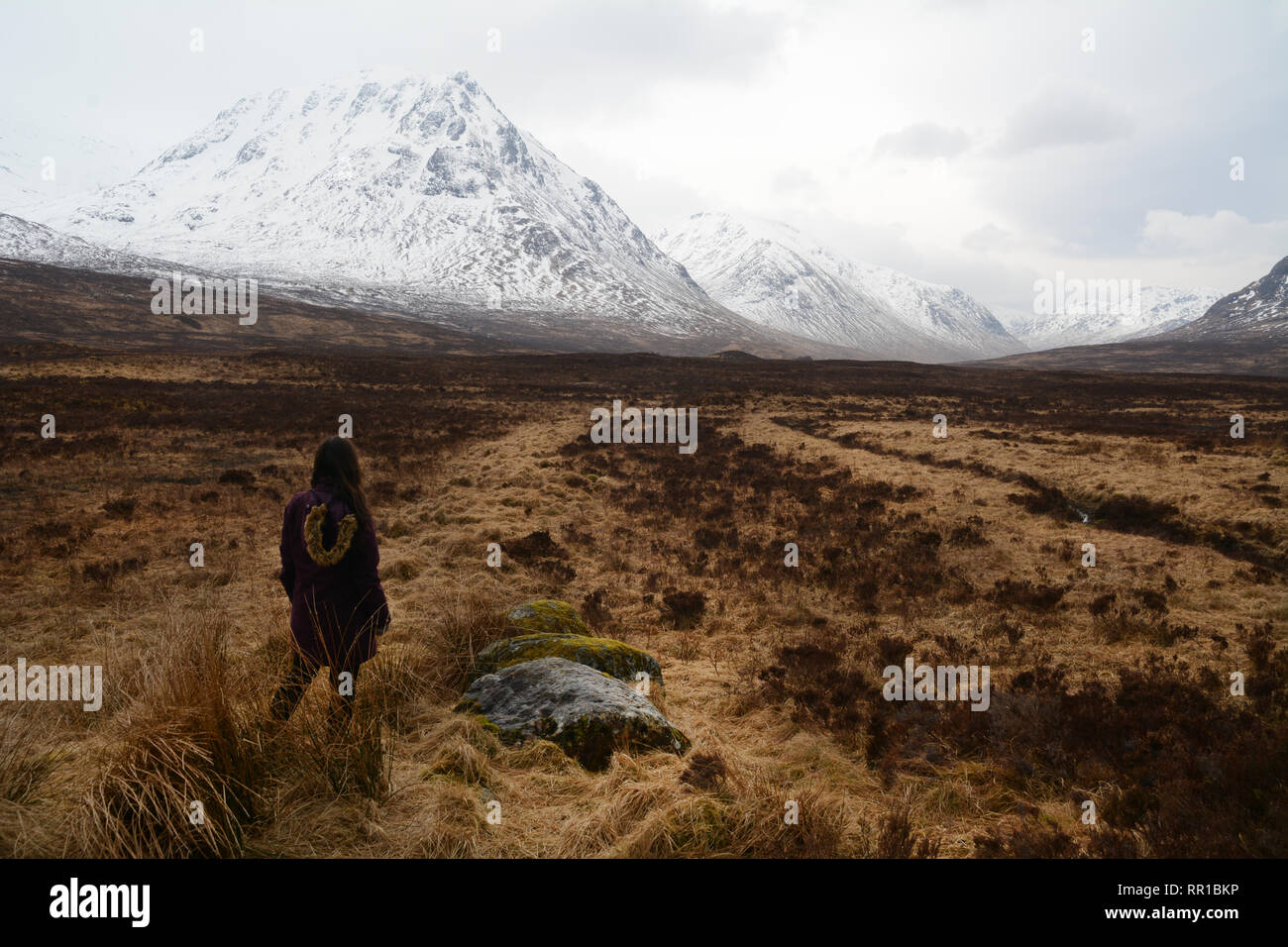 A Scottish woman amid snow covered mountains at the mouth of the Glen ...