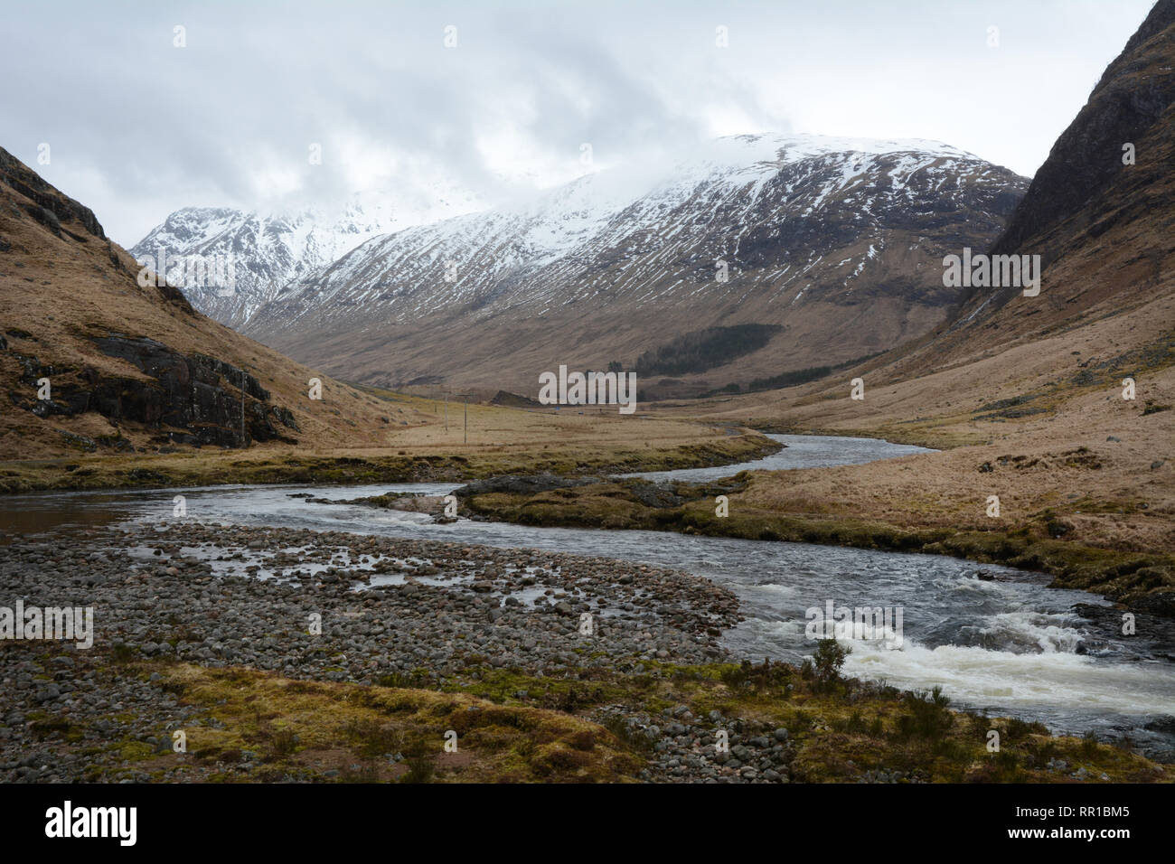 The River Etive flowing beneath the snow dusted mountains of the Glen ...