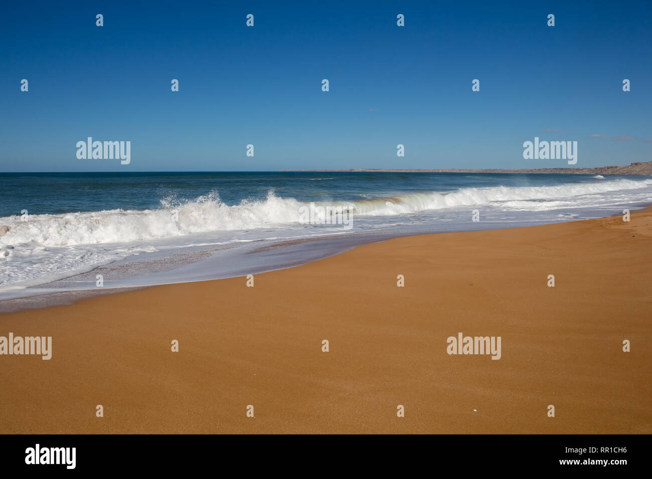 Clean dark yellow sand of the autumn beach. Deep blue color of the ...