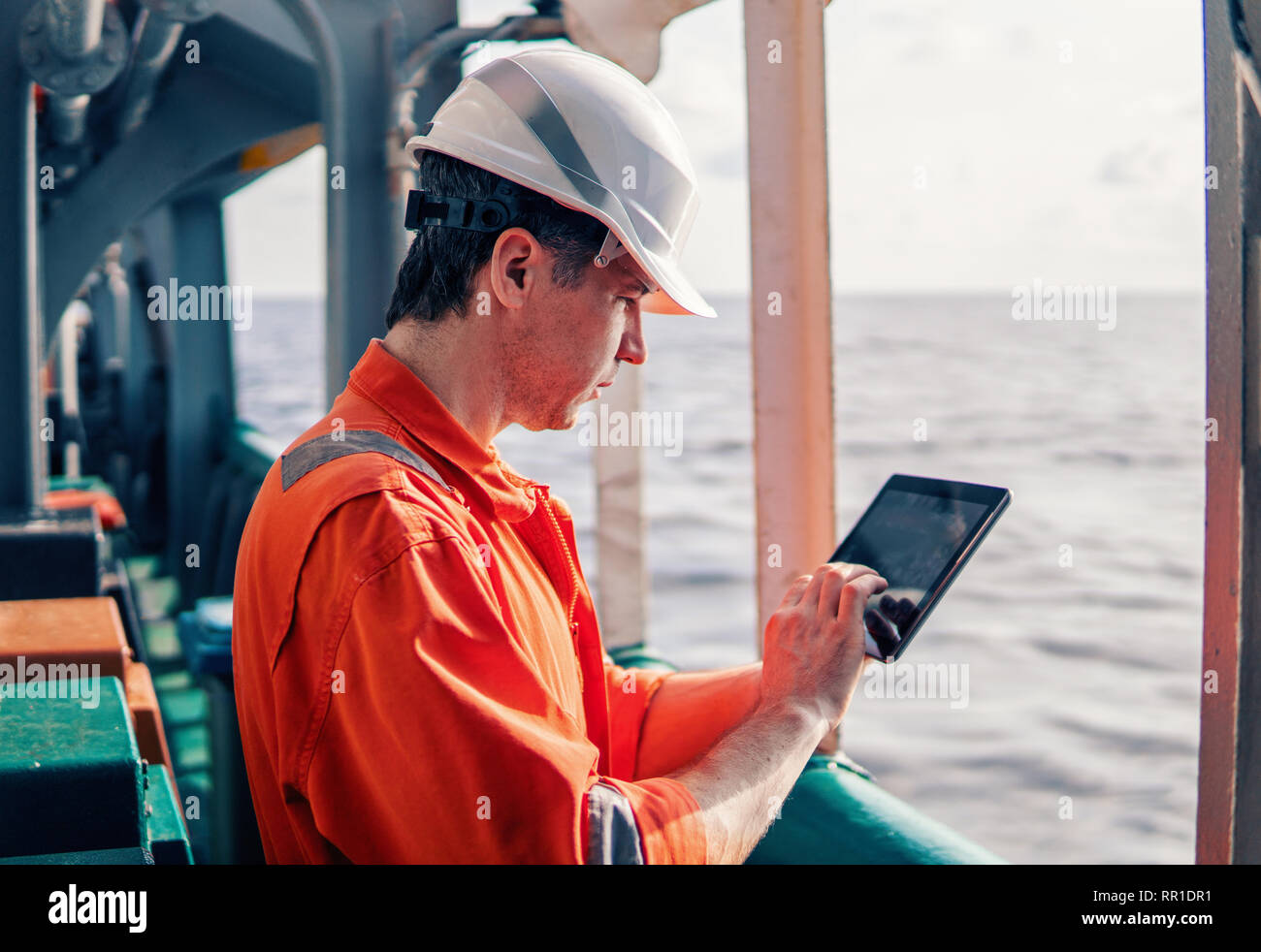 chief officer or captain on deck of vessel or ship watching digital ...