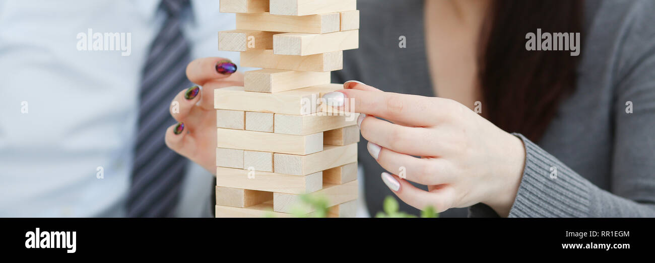 Businessman plays in a strategy of jenga hand Stock Photo - Alamy