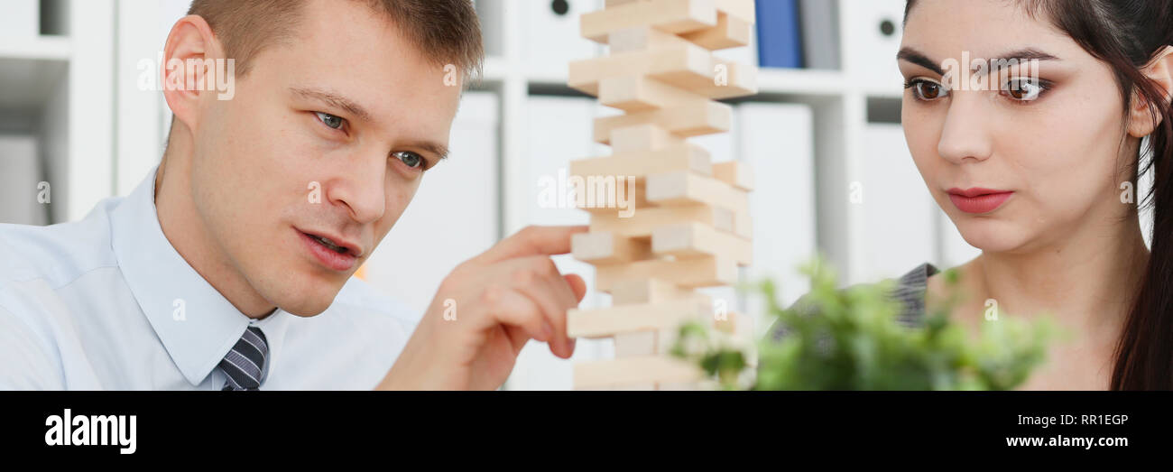 Businessman plays in a strategy of jenga hand Stock Photo - Alamy