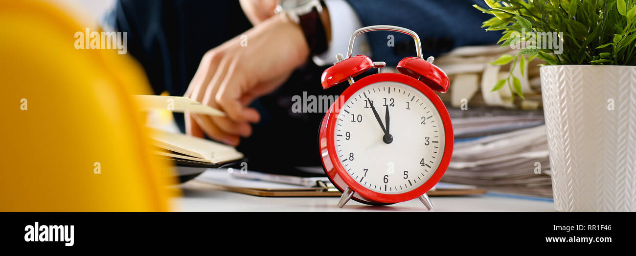 Red alarm clock shows late time closeup Stock Photo - Alamy