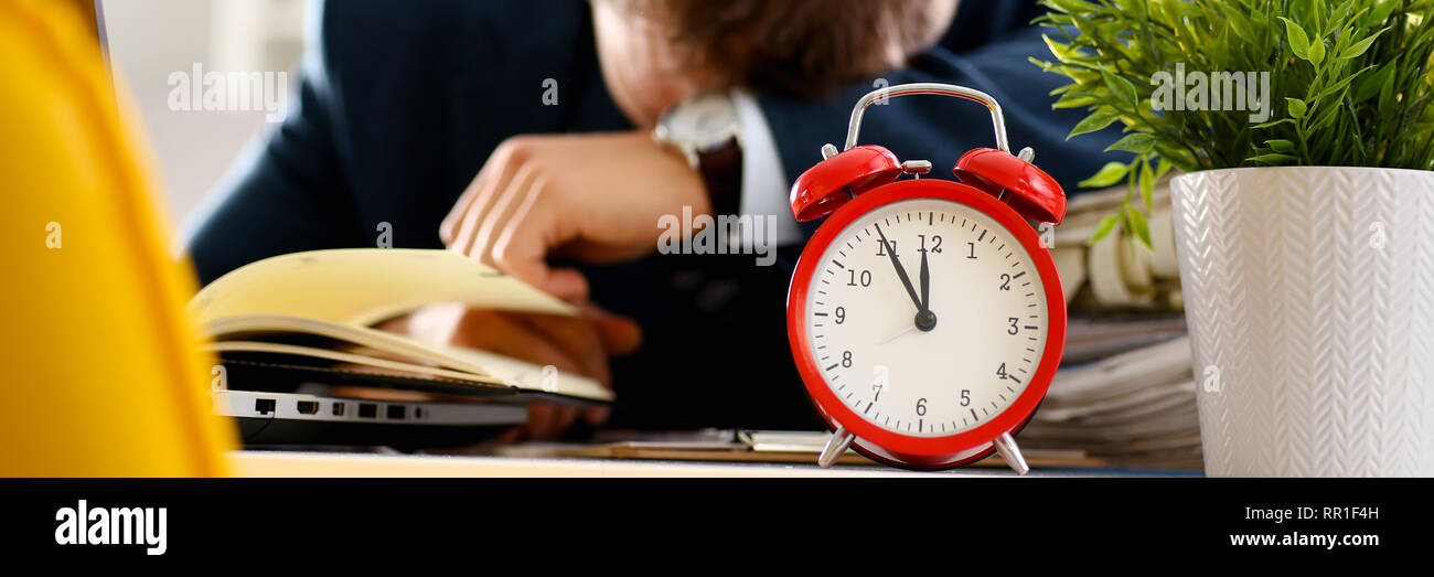 Red alarm clock shows late time closeup Stock Photo - Alamy