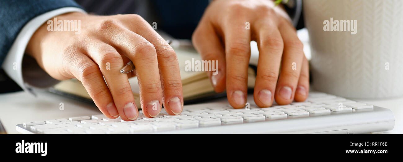 Male arms in suit typing on silver keyboard Stock Photo - Alamy