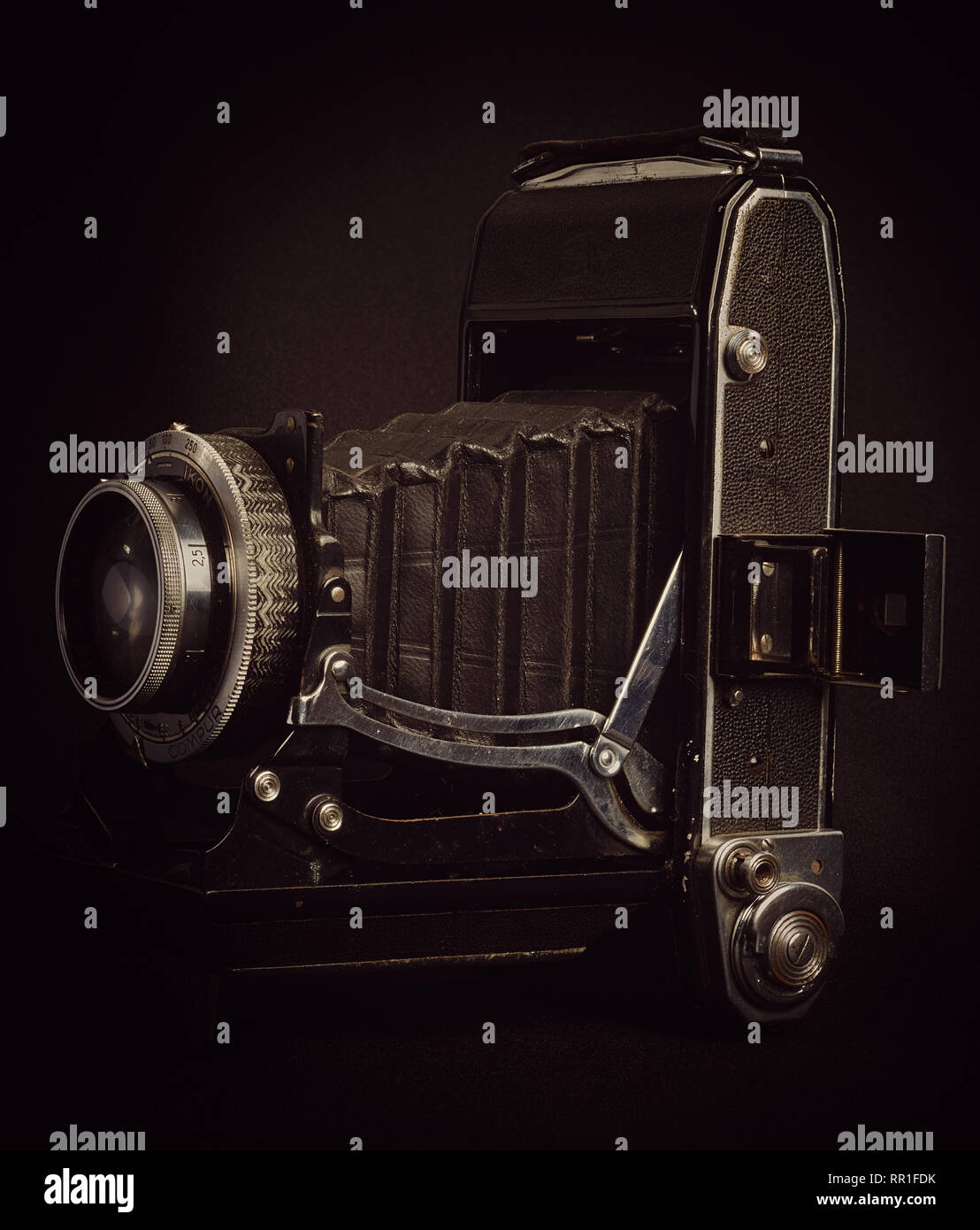 Vertical aspect left side view of a vintage bellows film camera against ...