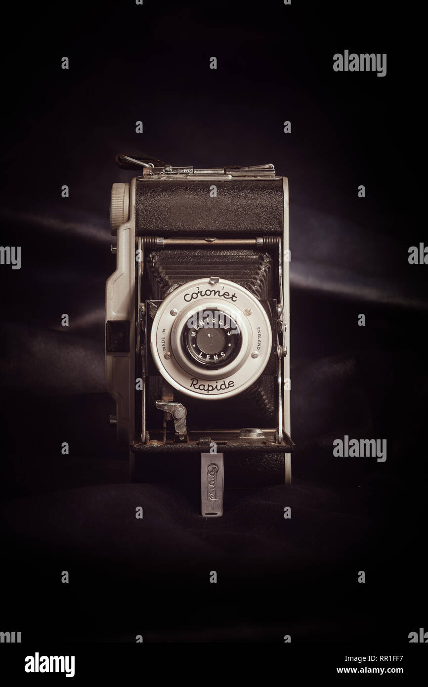 Vertical aspect front view of a vintage bellows film camera against a ...