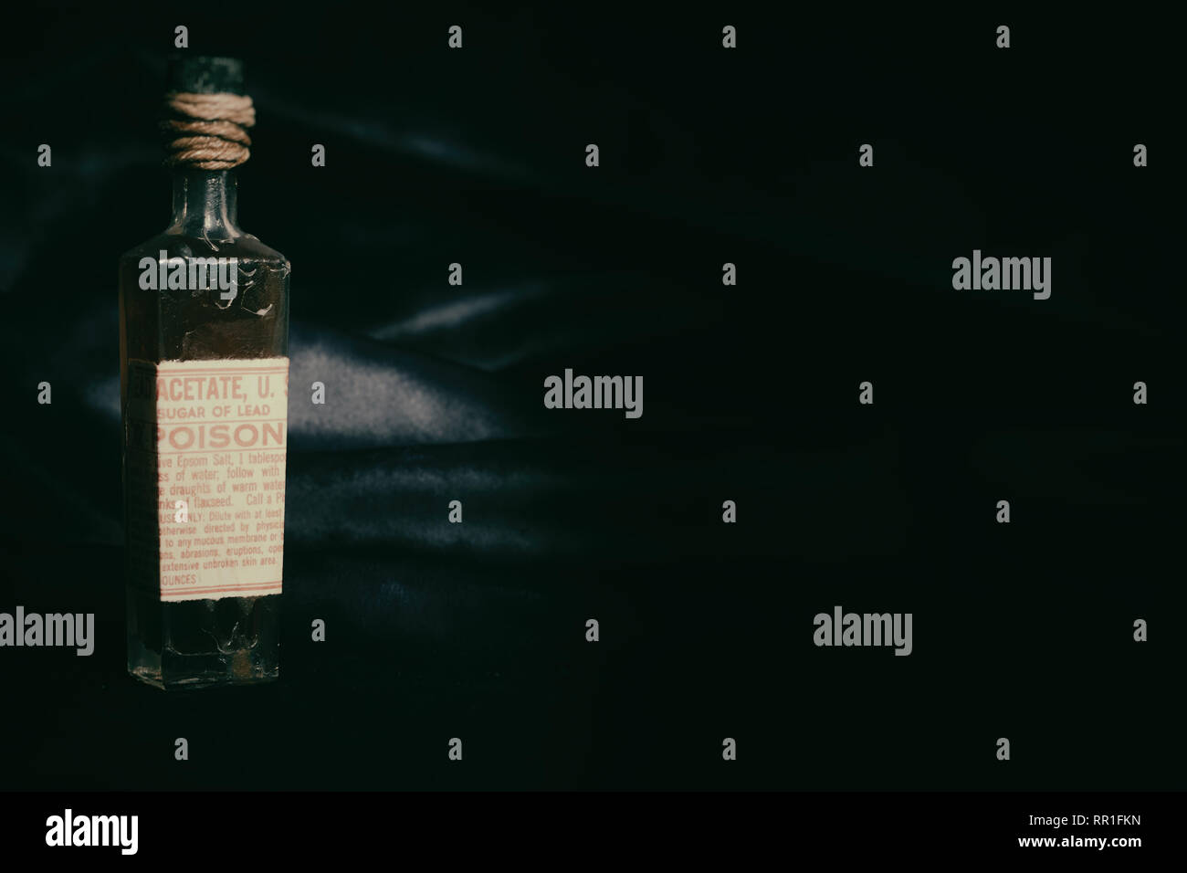 Single poison bottle against a black and blue background with dark ...