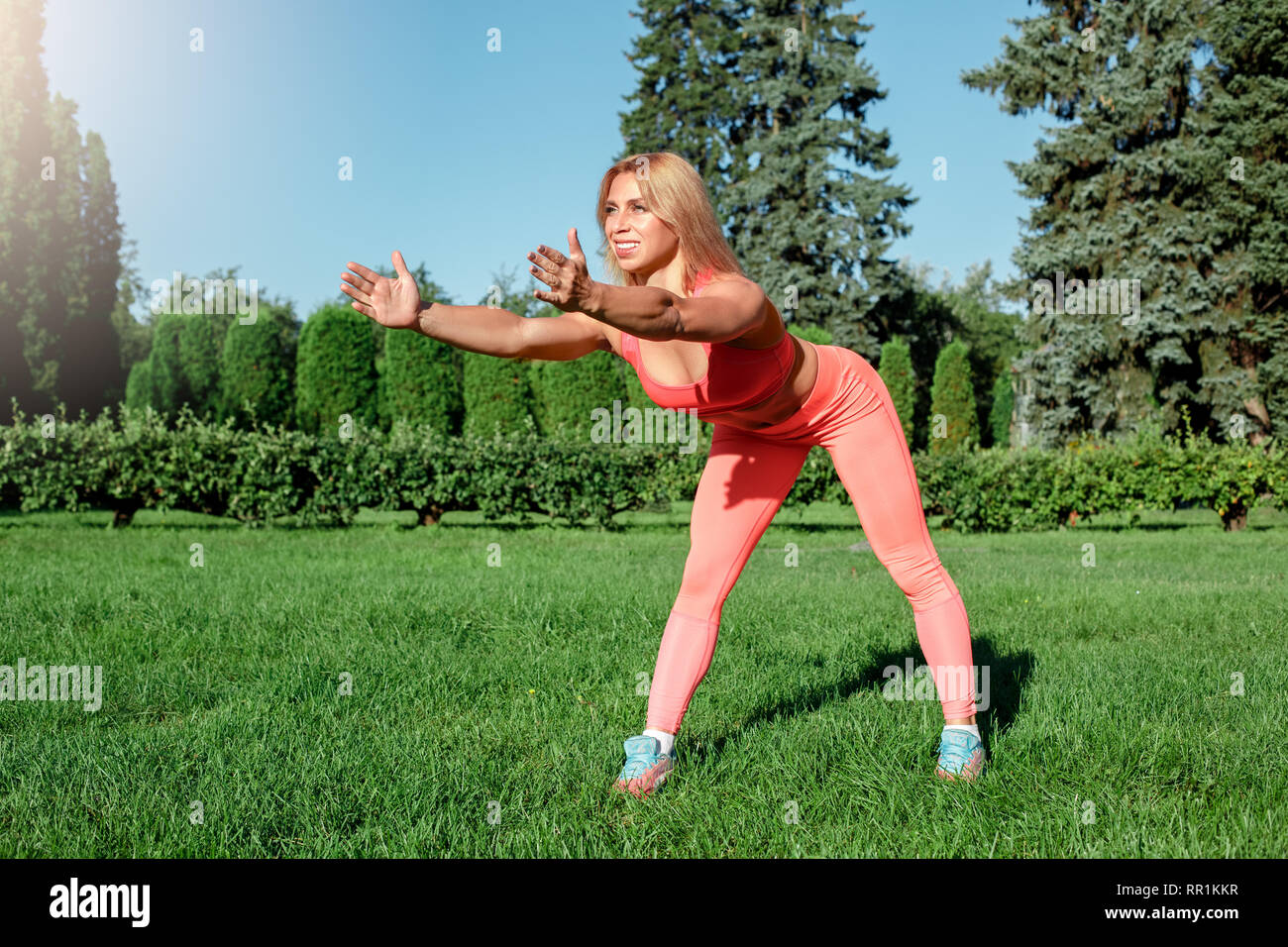 Healthy Lifestyle. Woman practicing yoga outdoors bending forward ...