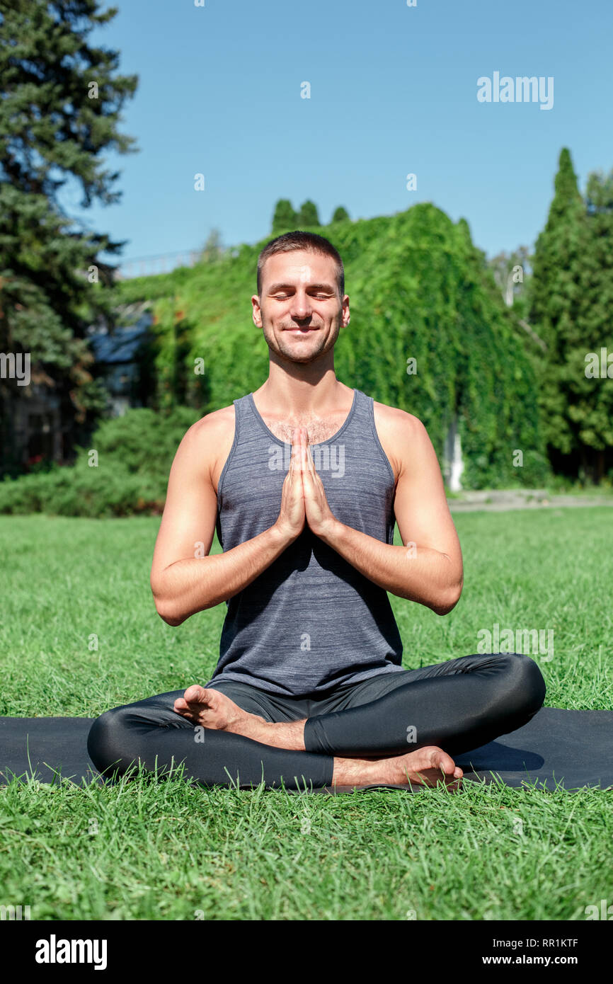 Healthy Lifestyle. Man practicing yoga outdoors sitting in lotus pose ...
