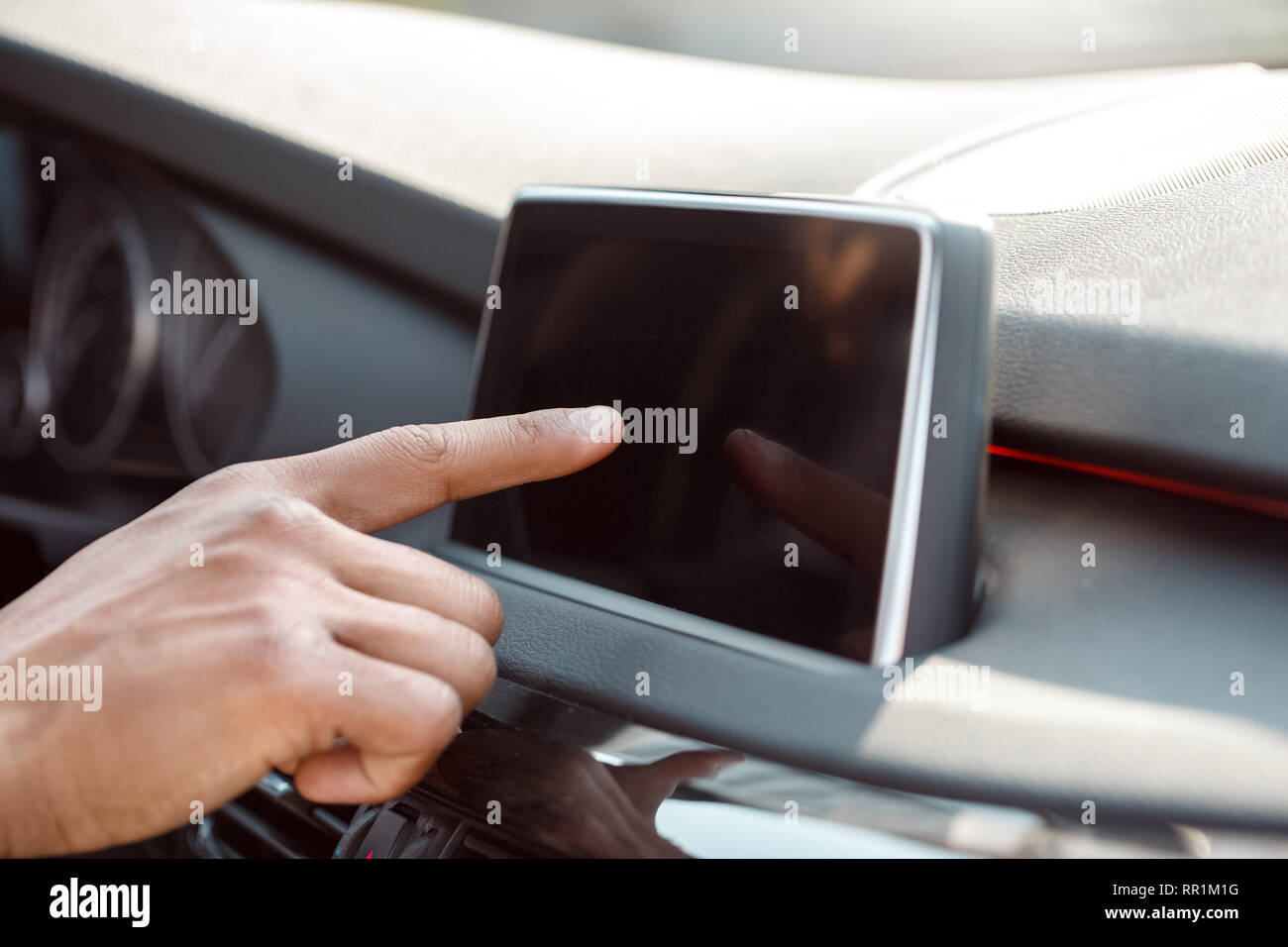 Young businessman driver sitting inside car touchign screen of control ...