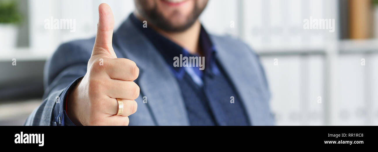 young handsome promising businessman work in office show big finger up ...