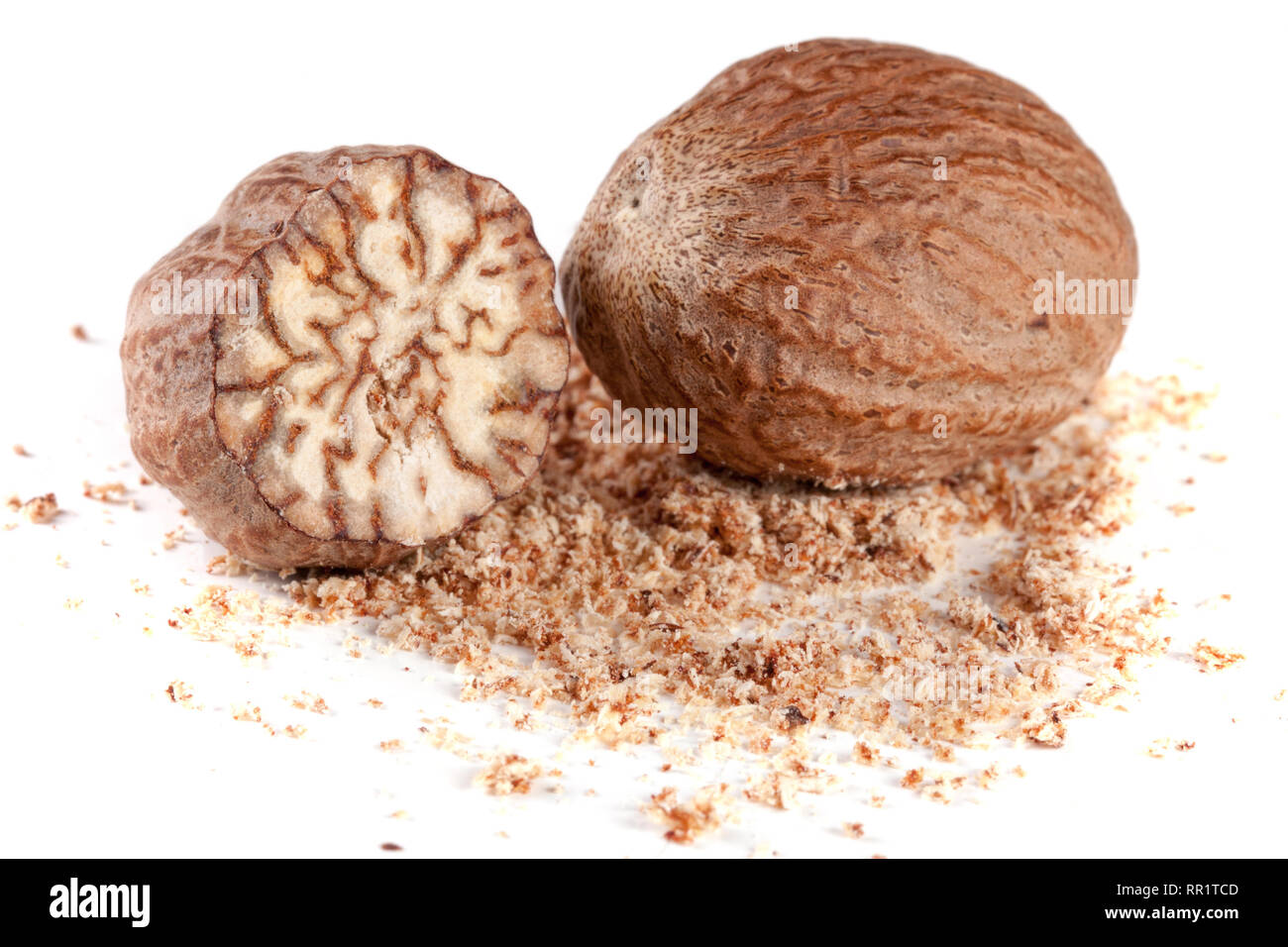 two nutmeg and powder isolated on white background Stock Photo - Alamy
