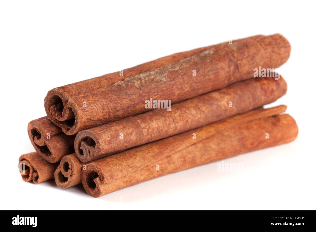 a stack of cinnamon sticks isolated on white background Stock Photo - Alamy