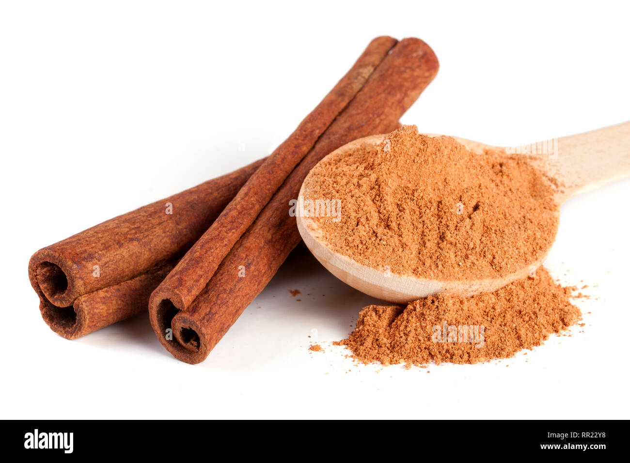 two cinnamon sticks and powder with spoon isolated on white background ...