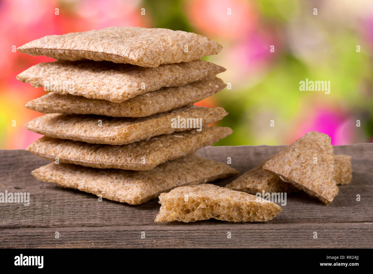 stack of crisp bread on a wooden table with blurred garden background ...