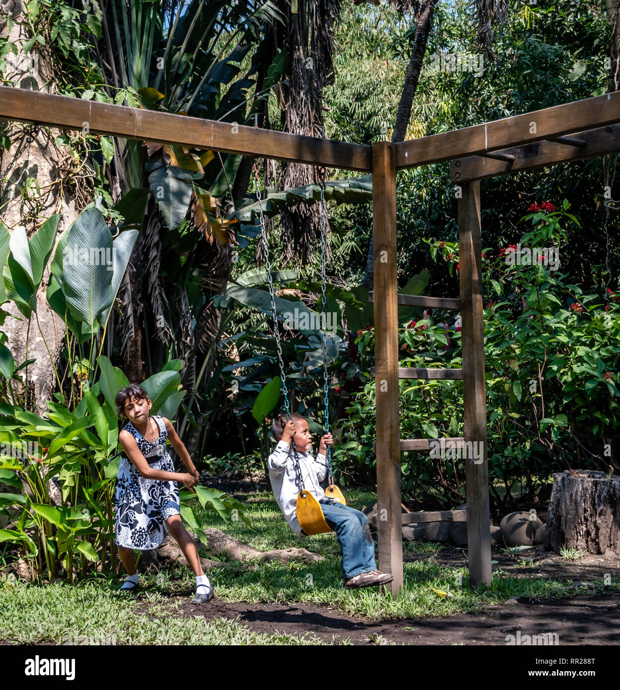 latin siblings playing on playground in Guatemala Stock Photo - Alamy