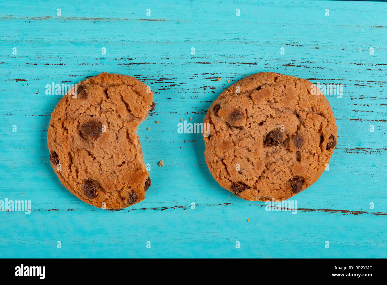 top view cookies on blue background and one with a bite Stock Photo - Alamy