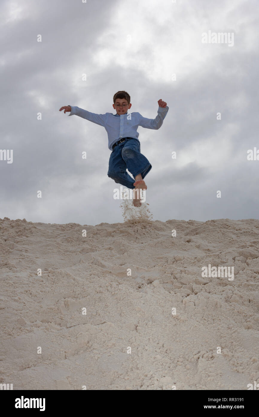 Boy jumping in sand dune Stock Photo - Alamy