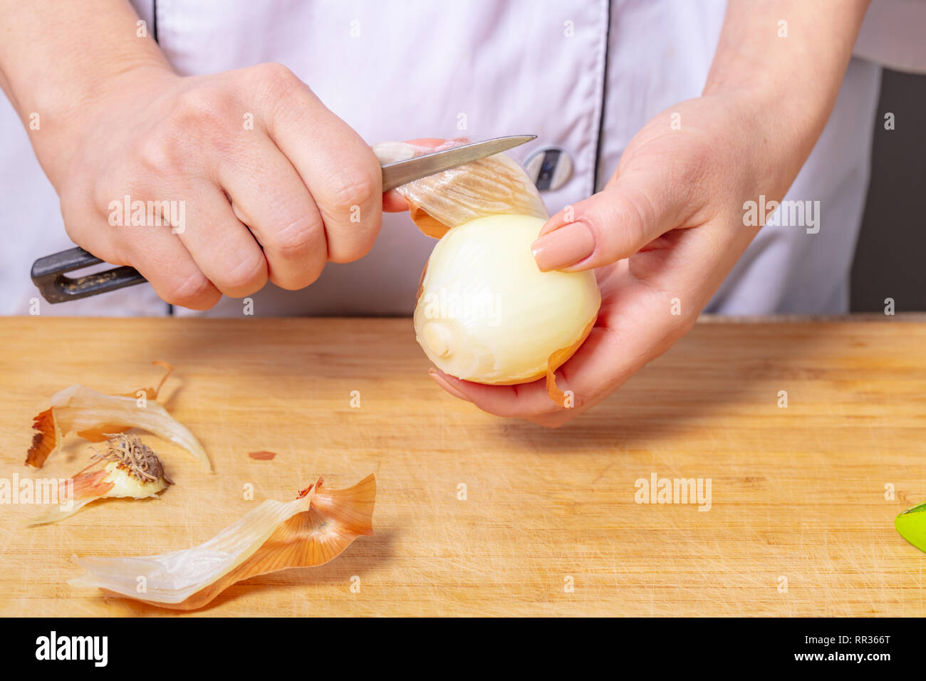 cook cleans the skin of an onion, hands close-up Stock Photo - Alamy
