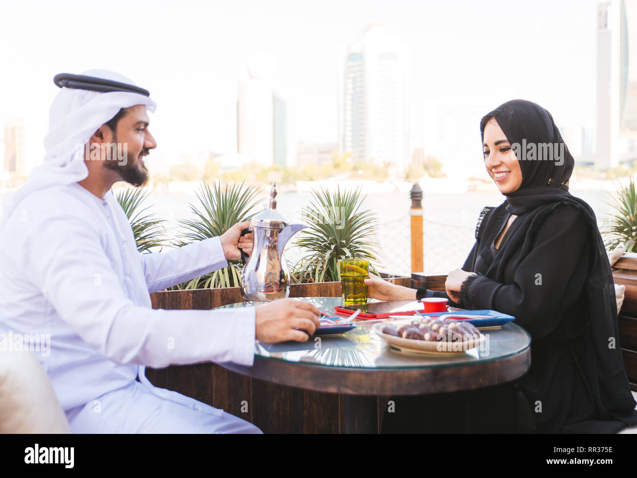 Arabian couple with traditional emirates dress dating outdoors - Happy ...
