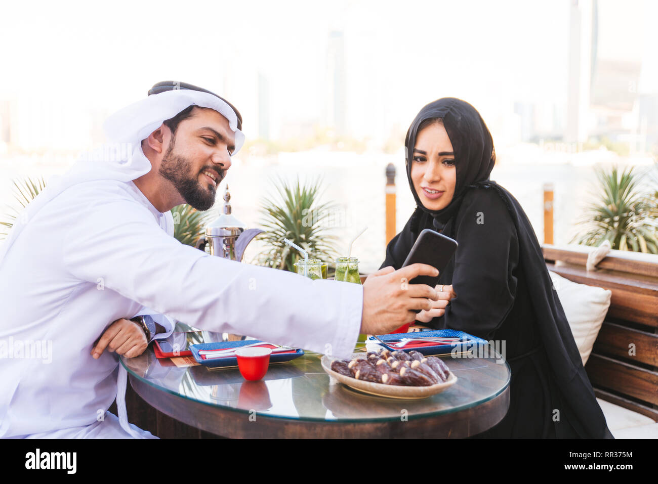 Arabian couple with traditional emirates dress dating outdoors - Happy ...
