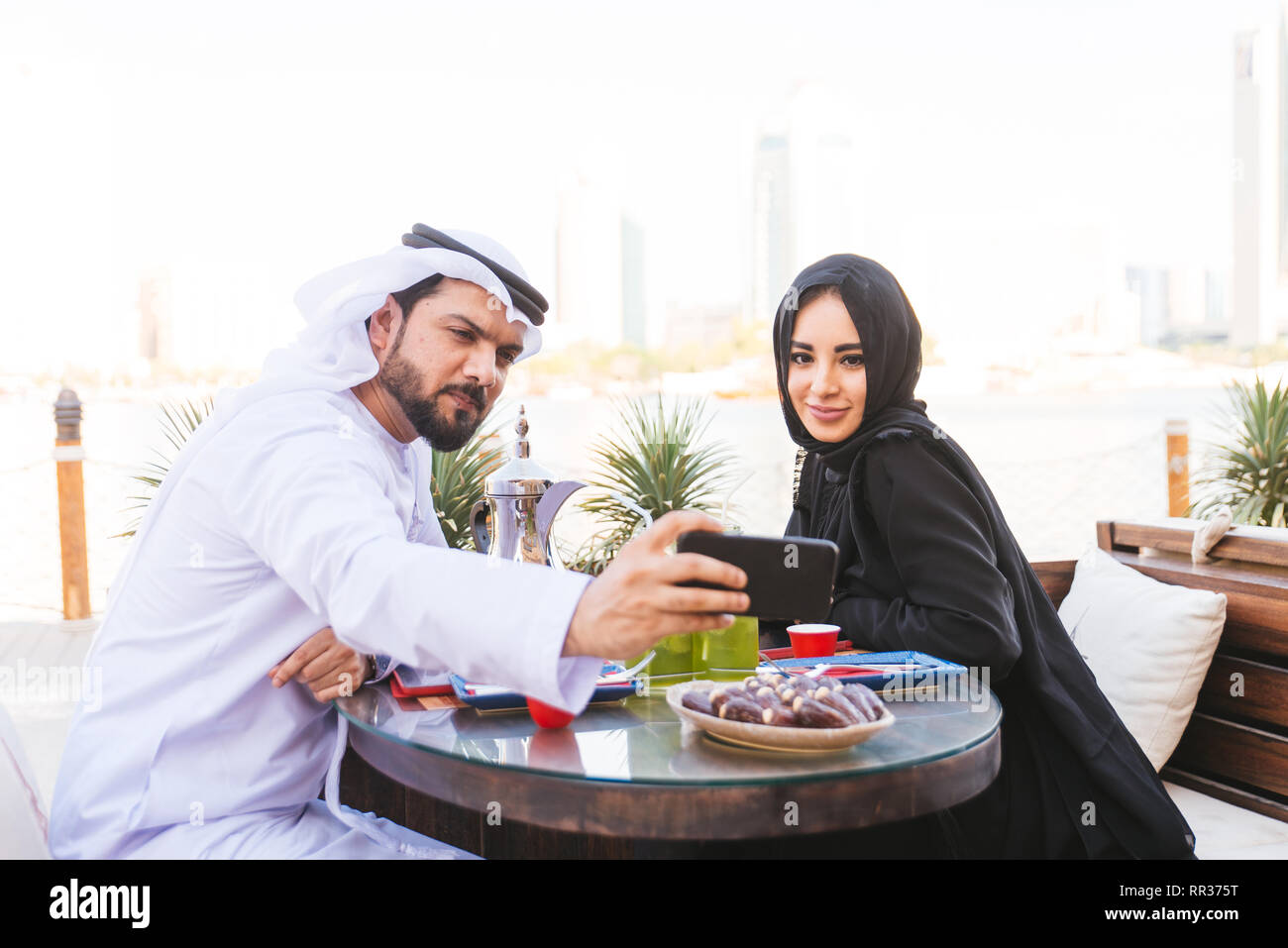 Arabian couple with traditional emirates dress dating outdoors - Happy ...
