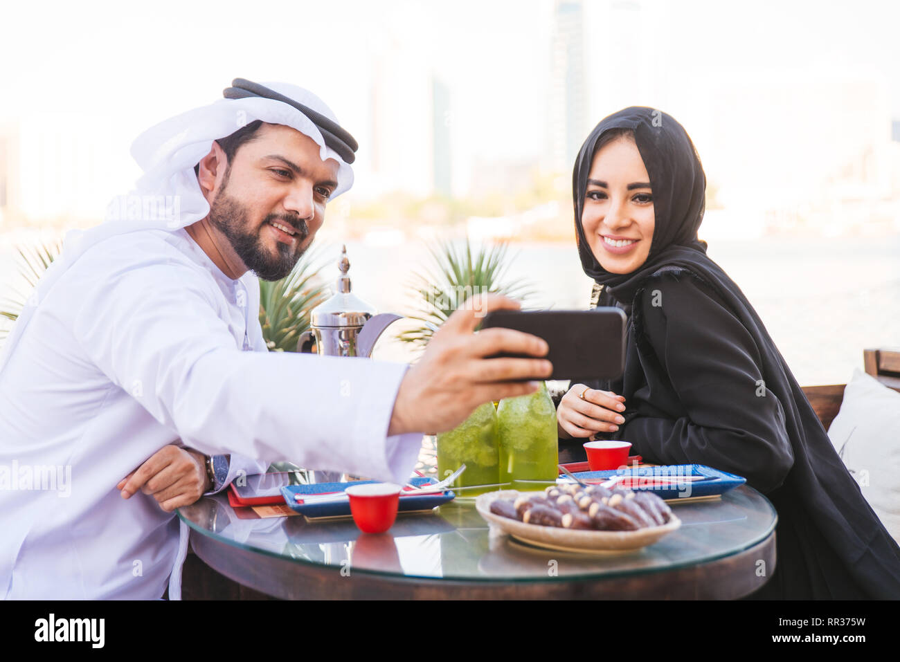 Arabian couple with traditional emirates dress dating outdoors - Happy ...