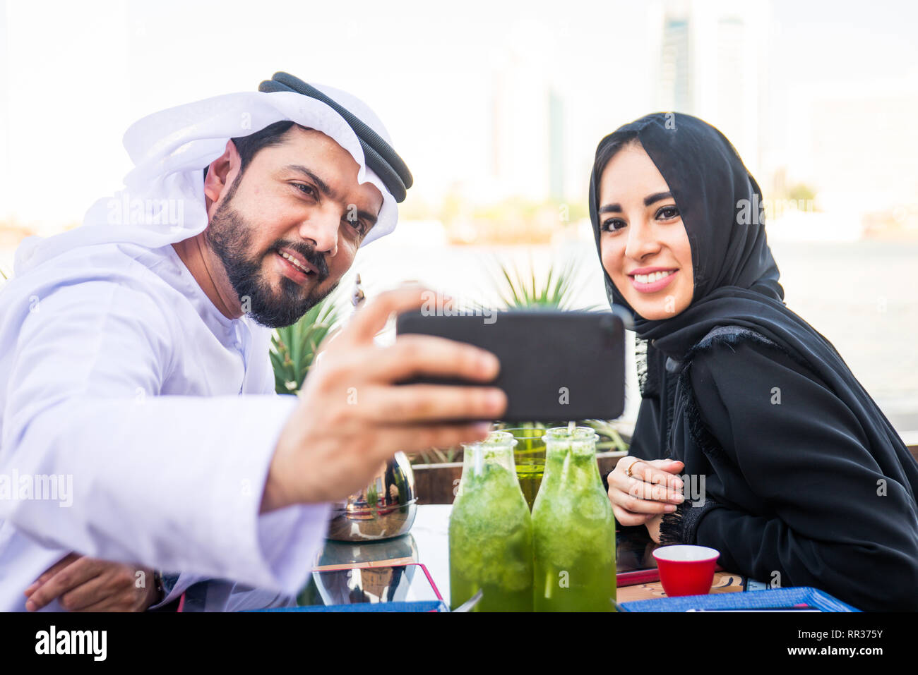 Arabian couple with traditional emirates dress dating outdoors - Happy ...