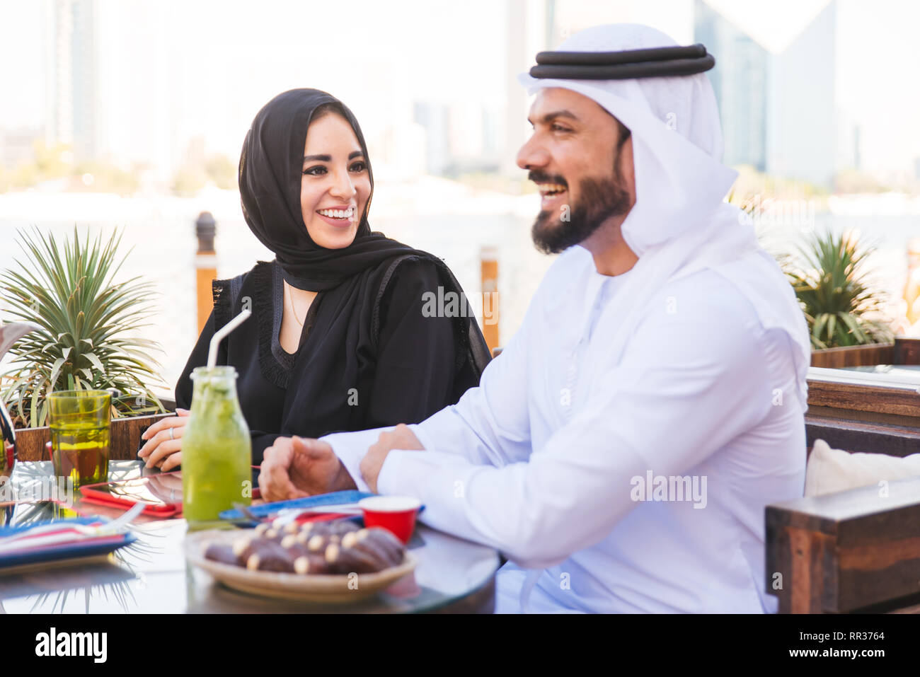 Arabian couple with traditional emirates dress dating outdoors - Happy ...