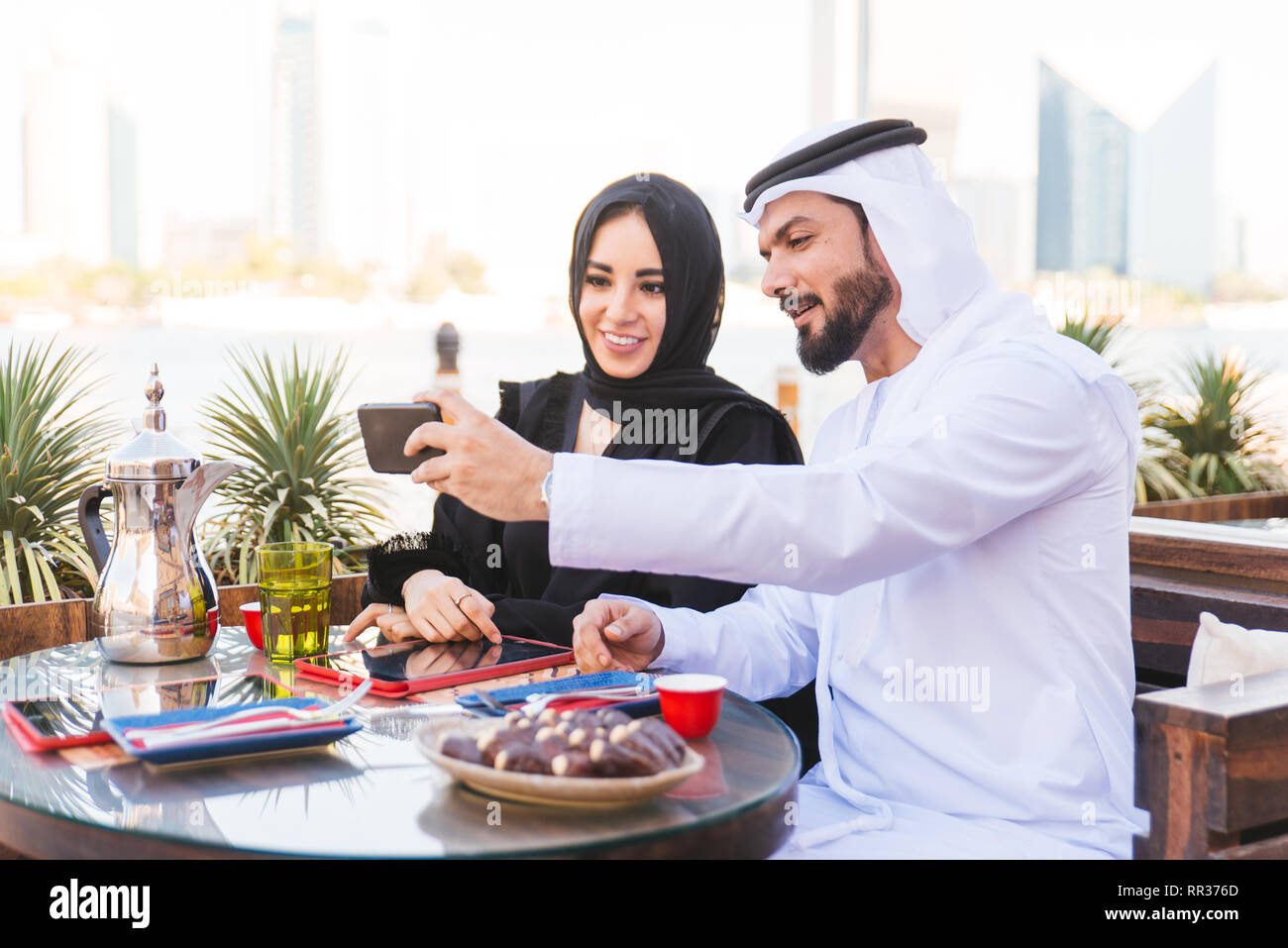 Arabian couple with traditional emirates dress dating outdoors - Happy ...