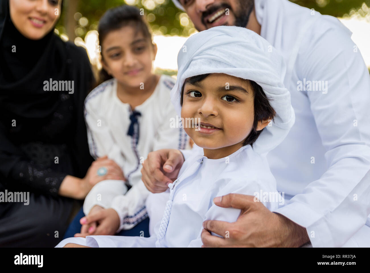 Happy middle-eastern family having fun in a park in Dubai - Parents and ...