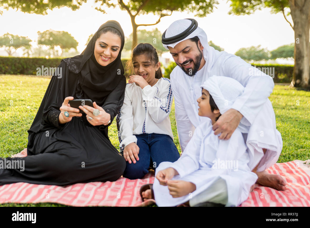 Happy middle-eastern family having fun in a park in Dubai - Parents and ...