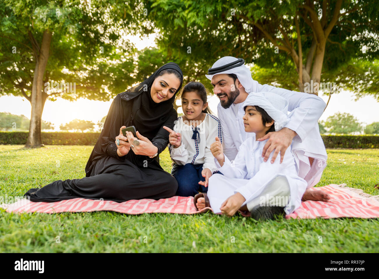 Happy middle-eastern family having fun in a park in Dubai - Parents and ...