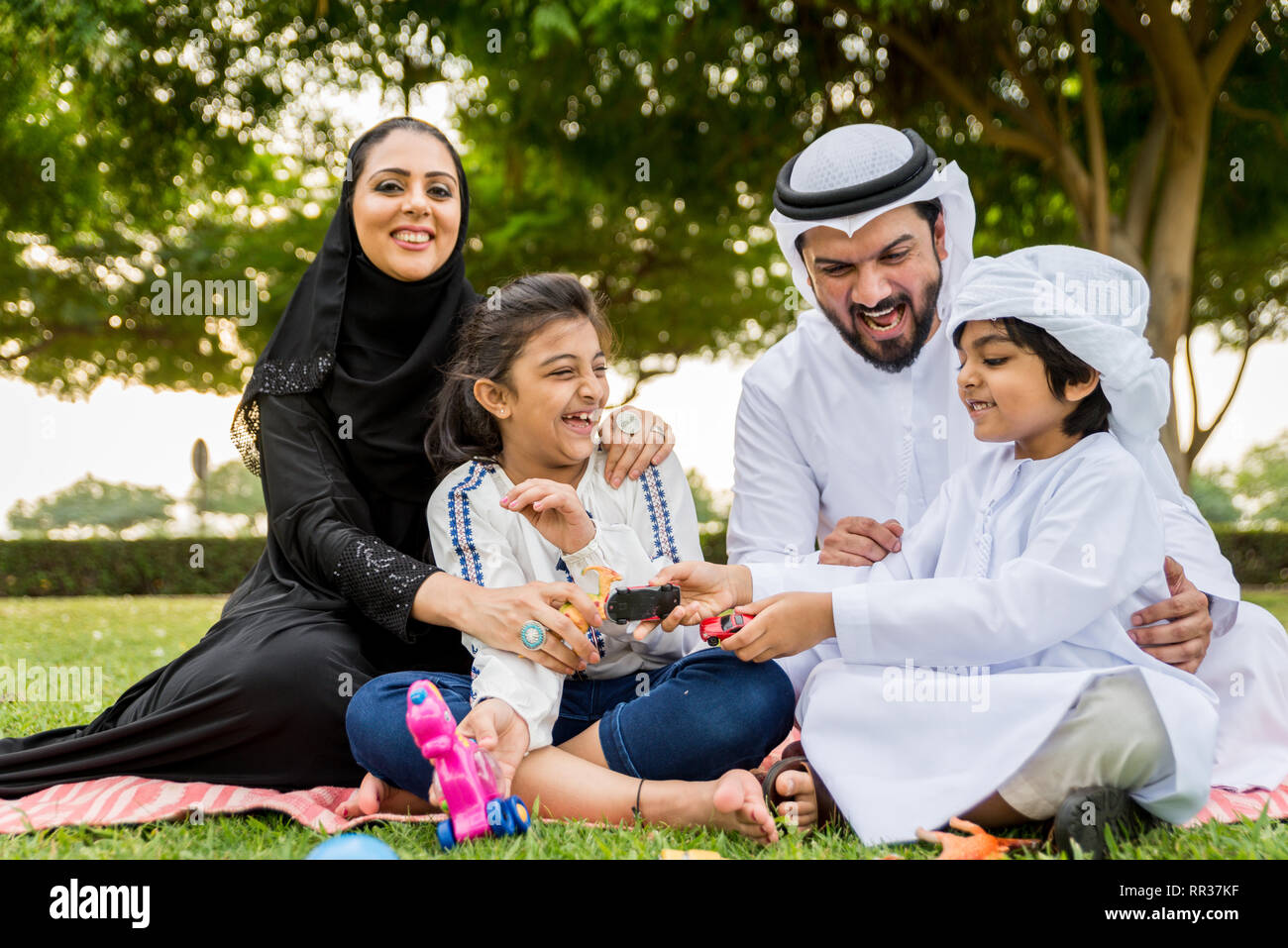 Happy middle-eastern family having fun in a park in Dubai - Parents and ...