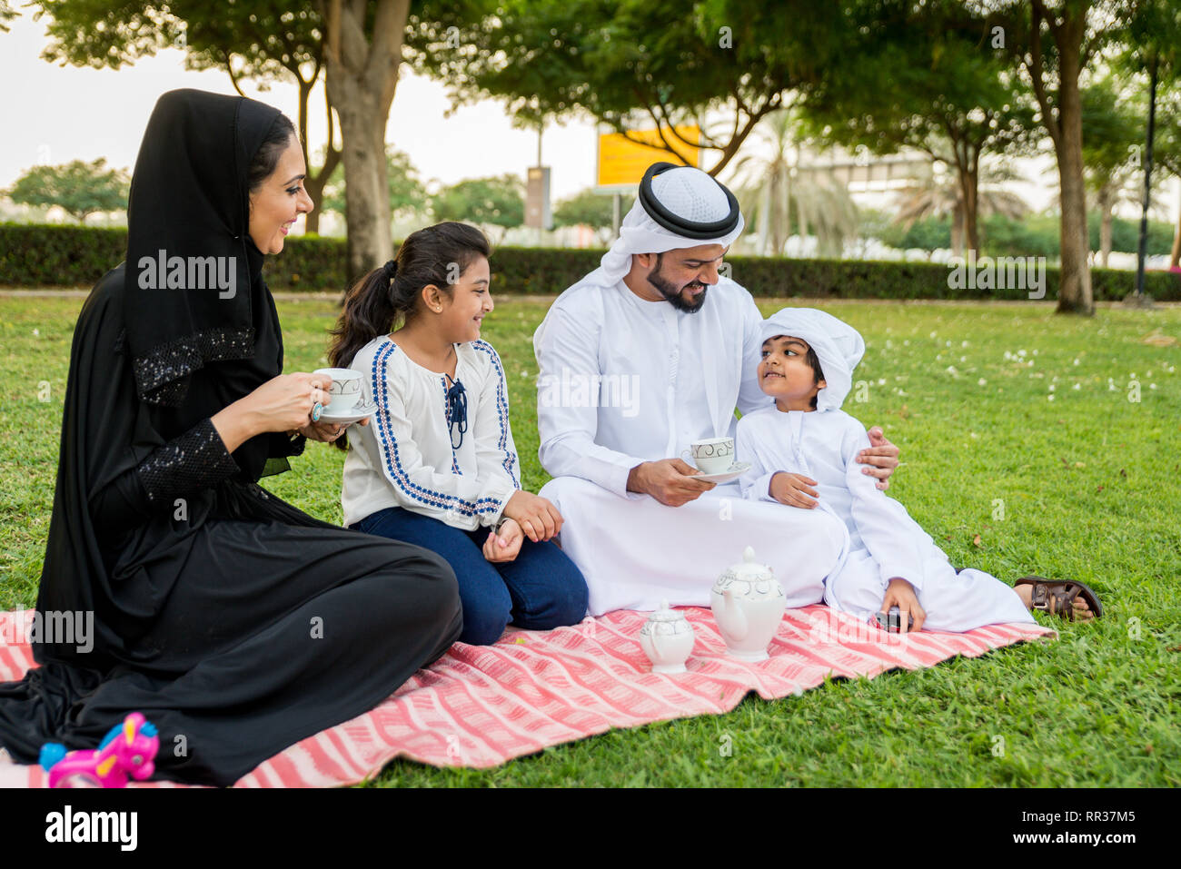 Happy middle-eastern family having fun in a park in Dubai - Parents and ...