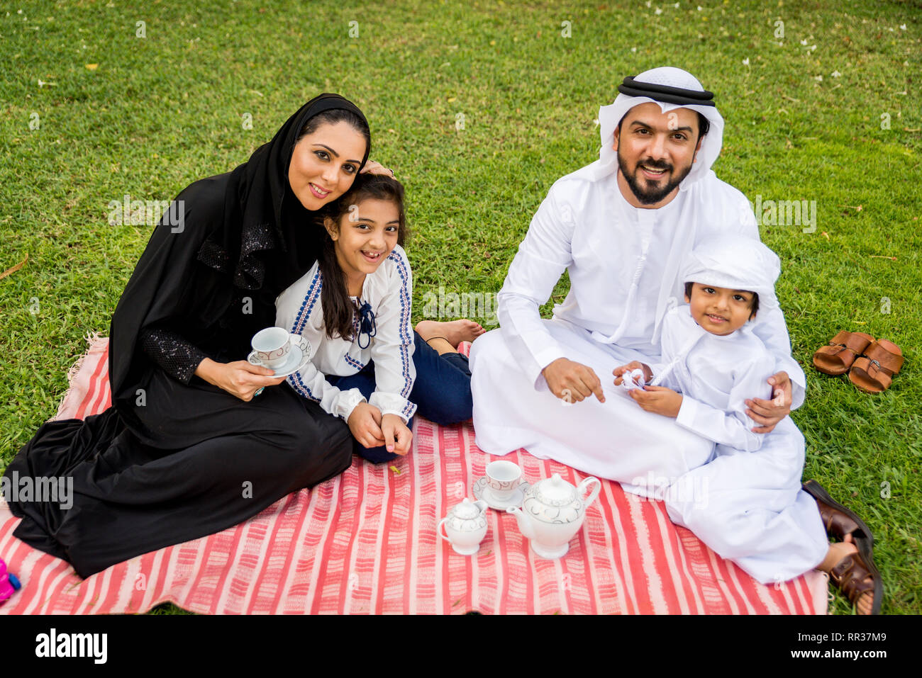 Happy middle-eastern family having fun in a park in Dubai - Parents and ...