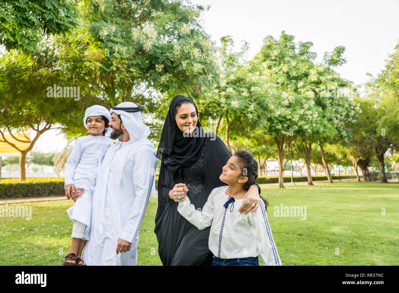 Happy middle-eastern family having fun in a park in Dubai - Parents and ...