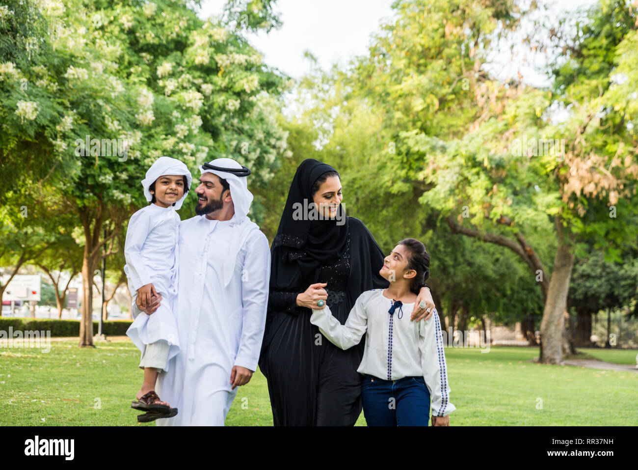 Happy middle-eastern family having fun in a park in Dubai - Parents and ...