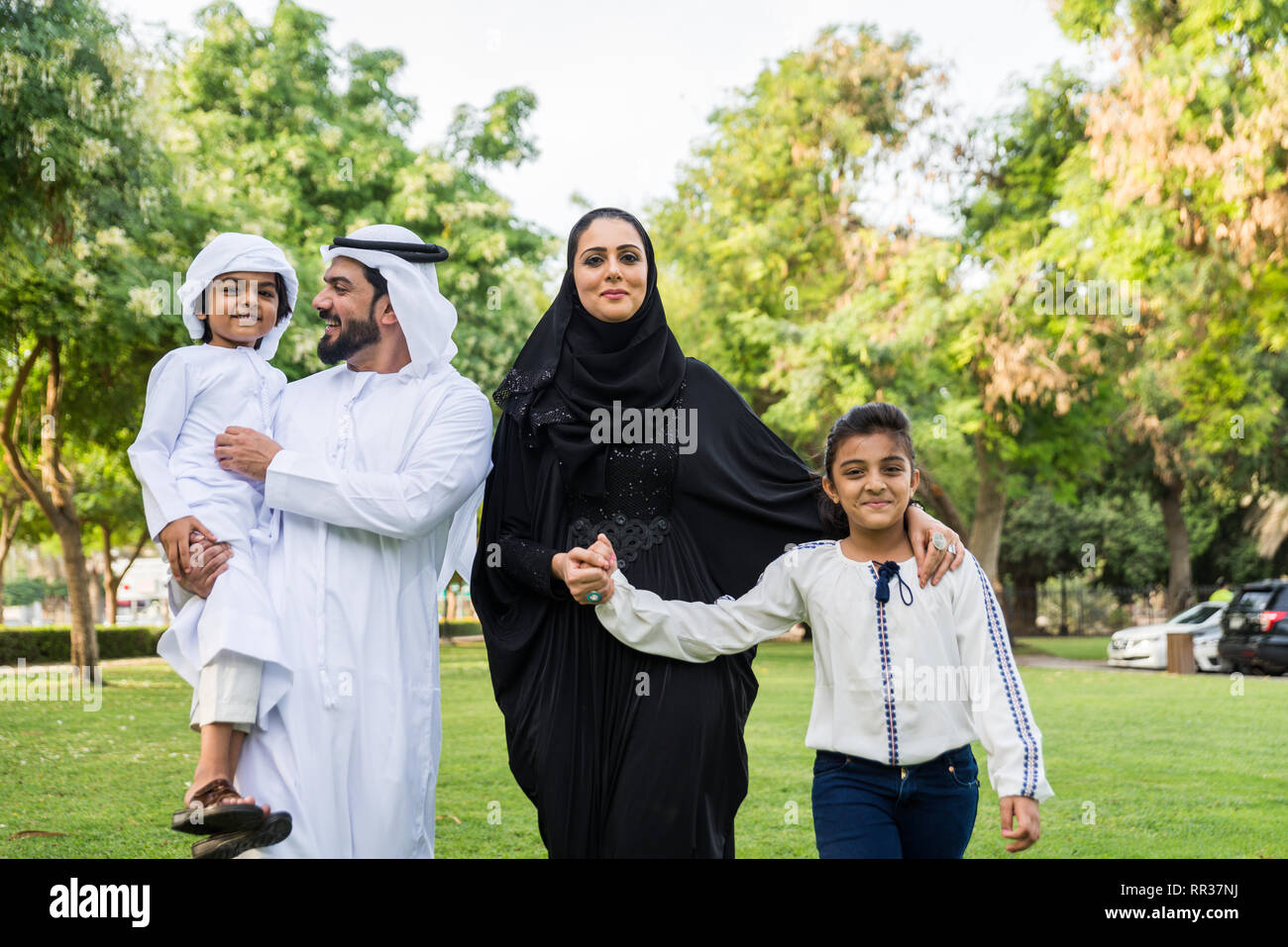 Happy middle-eastern family having fun in a park in Dubai - Parents and ...