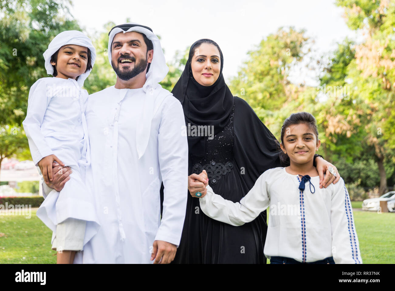 Happy middle-eastern family having fun in a park in Dubai - Parents and ...