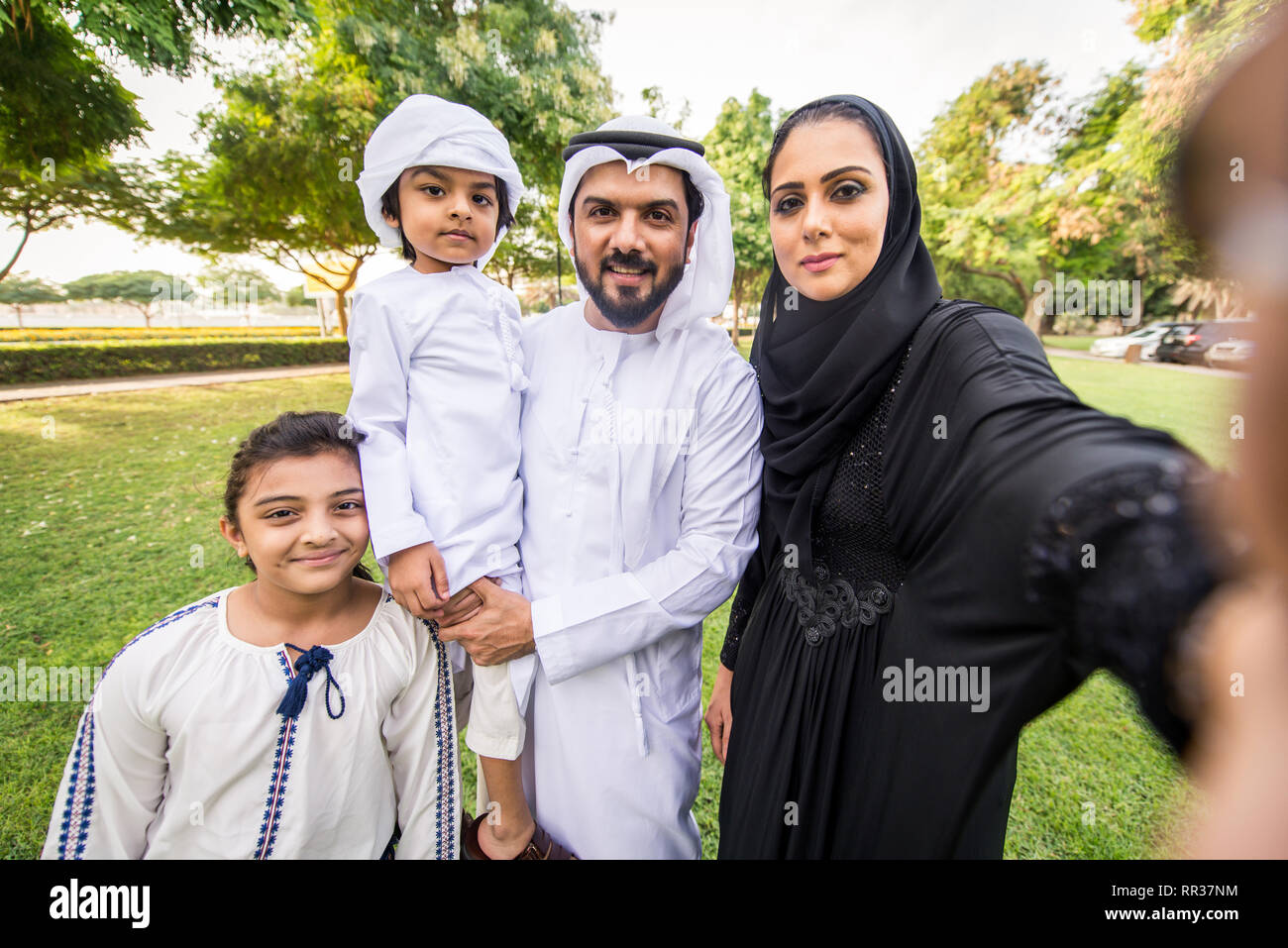 Happy middle-eastern family having fun in a park in Dubai - Parents and ...