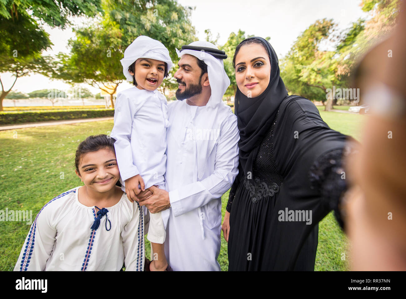 Happy middle-eastern family having fun in a park in Dubai - Parents and ...